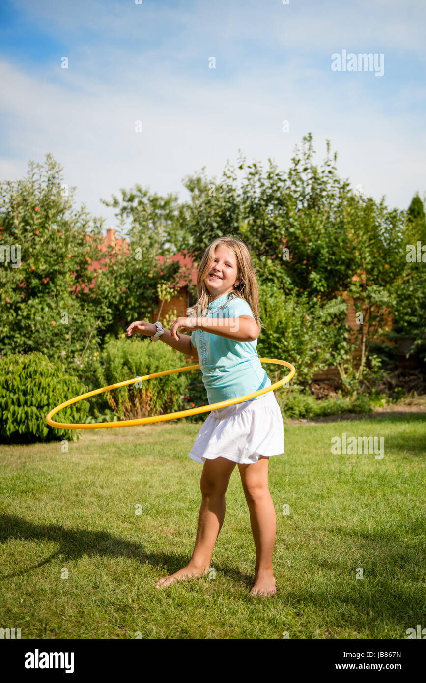 Active child - girl dancing with hoop outdoor in sunny backyard Stock ...