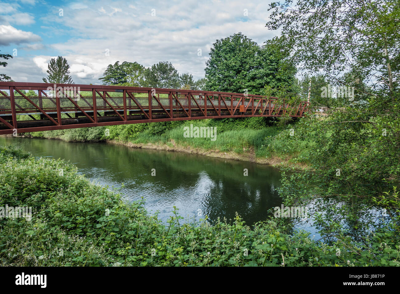 A rusted metal bridge spans the Green River in Kent, Washington Stock ...