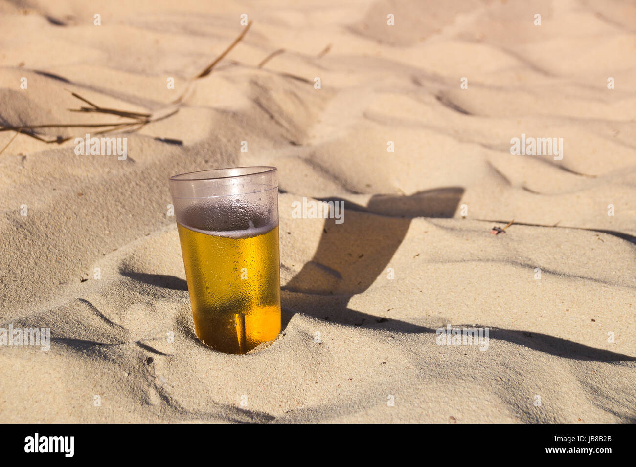 Photograph of a glass of beer on beach sand Stock Photo - Alamy