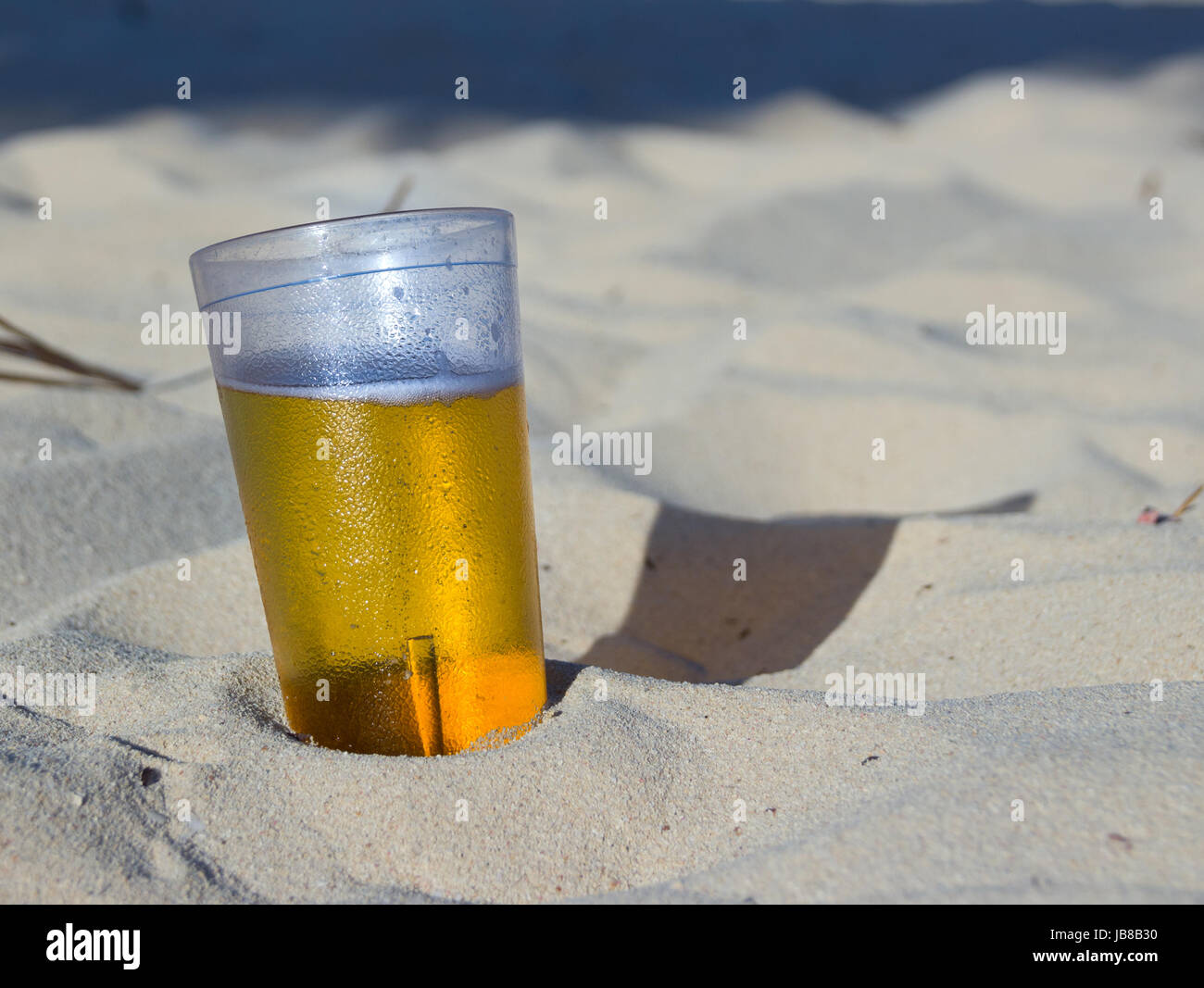 Photograph of a glass of beer on beach sand Stock Photo - Alamy