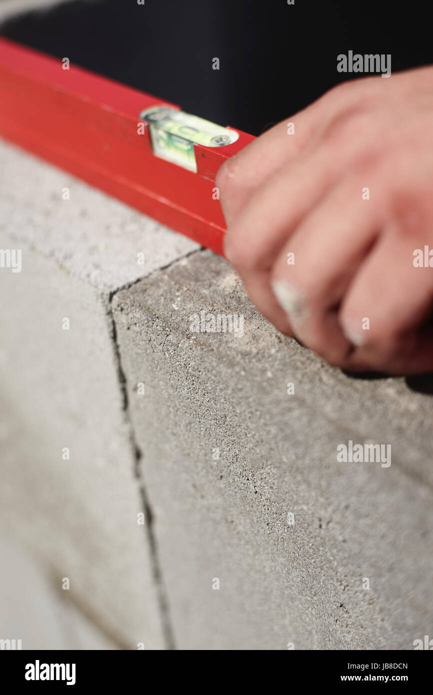 construction worker, bricklayer or mason laying bricks and creating ...