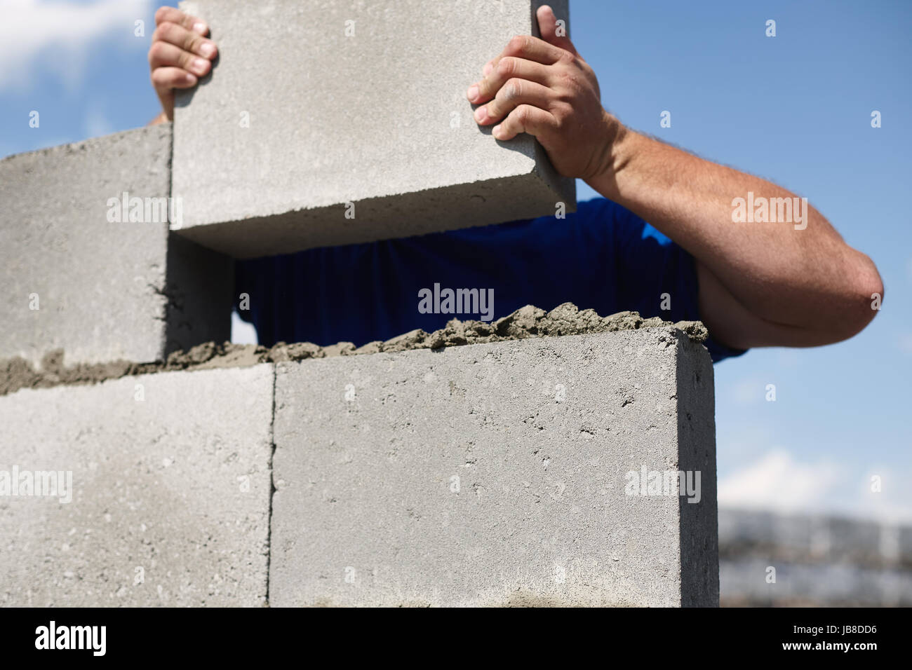 Close up of industrial bricklayer installing bricks on construction ...