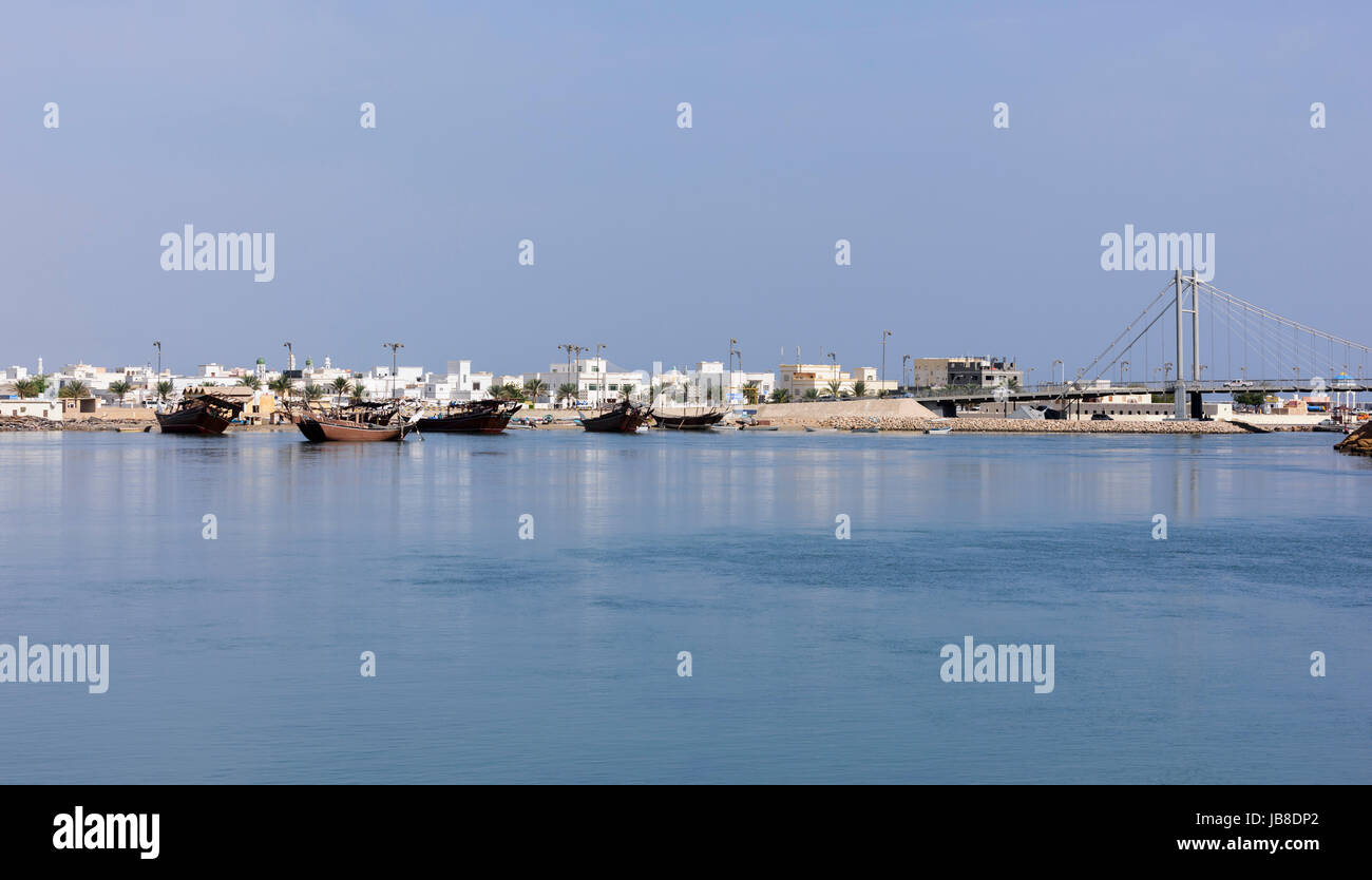 View of a part of the city of Sur with some traditional Arabic dhows in ...