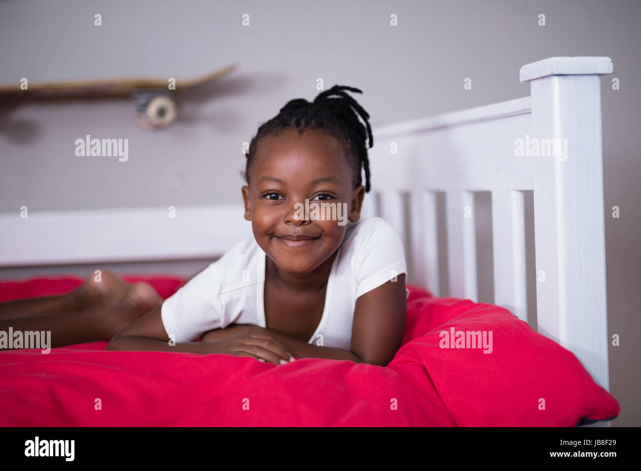 Portrait of smiling girl lying on bed at home Stock Photo - Alamy