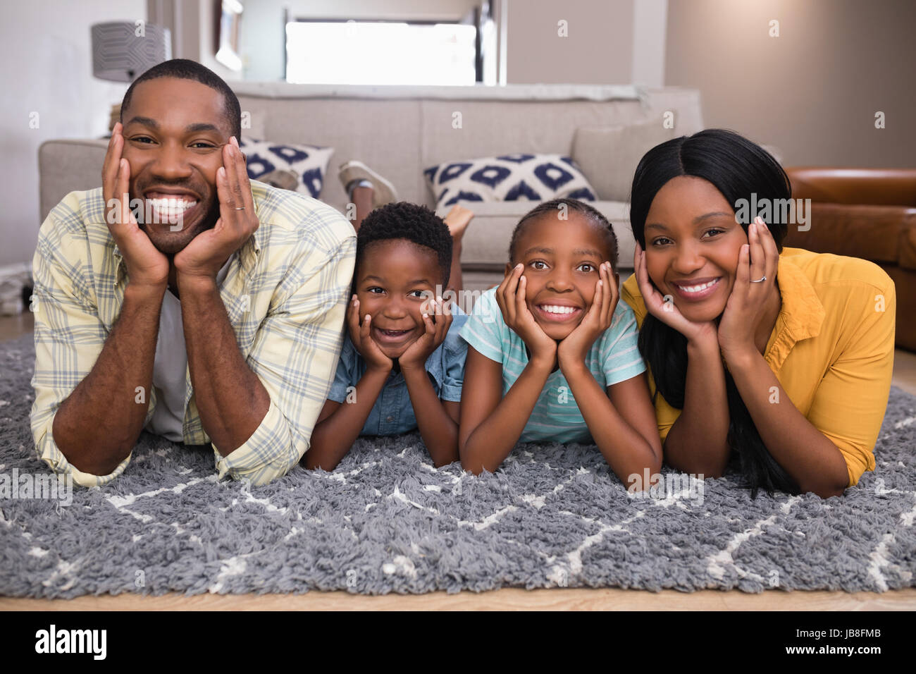 Portrait of smiling family lying on rug at home Stock Photo - Alamy
