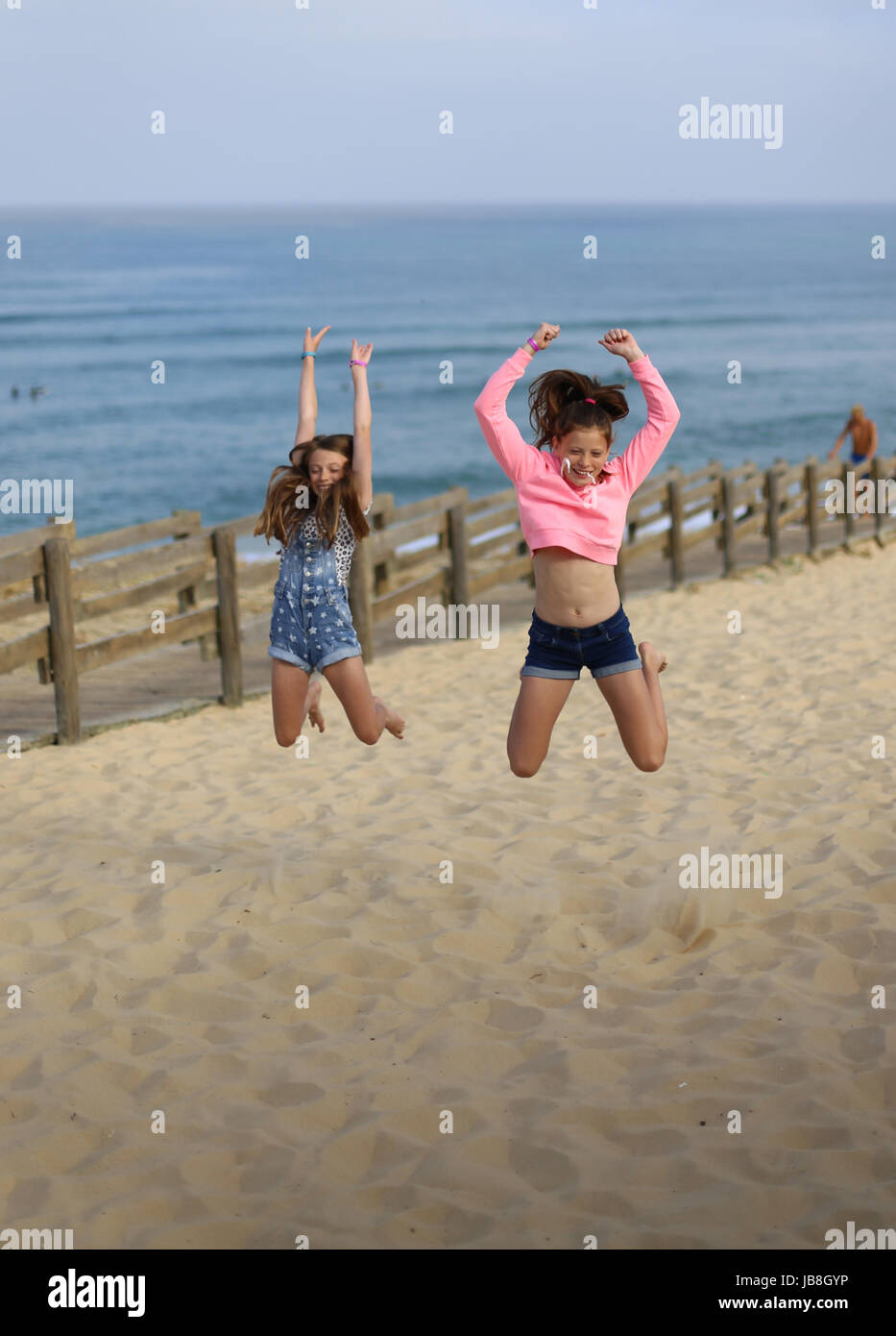 Jumping for joy in the air on the beach beside the ocean on Messanges ...