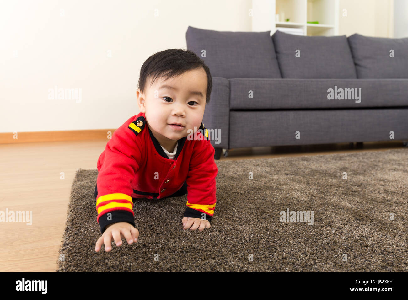 Baby boy creeping on carpet Stock Photo - Alamy