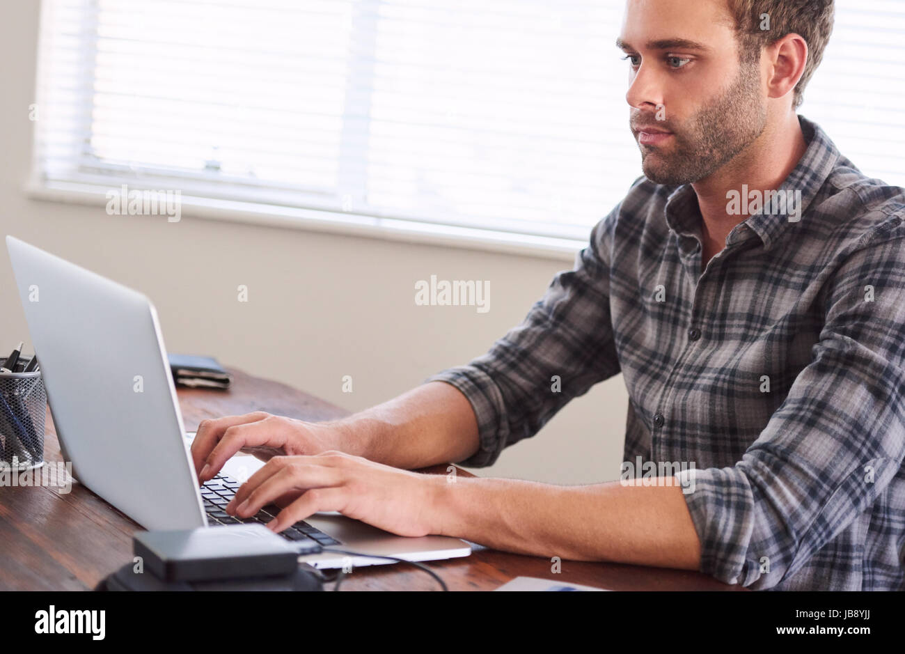 Young adult man looking frustrated and fed-up with work, while still ...