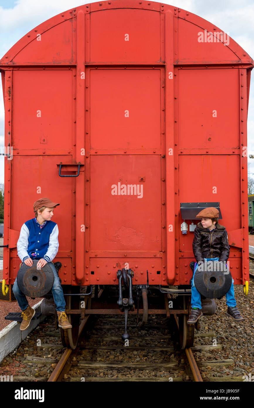 two kids secretly take a ride on the back of a train Stock Photo - Alamy