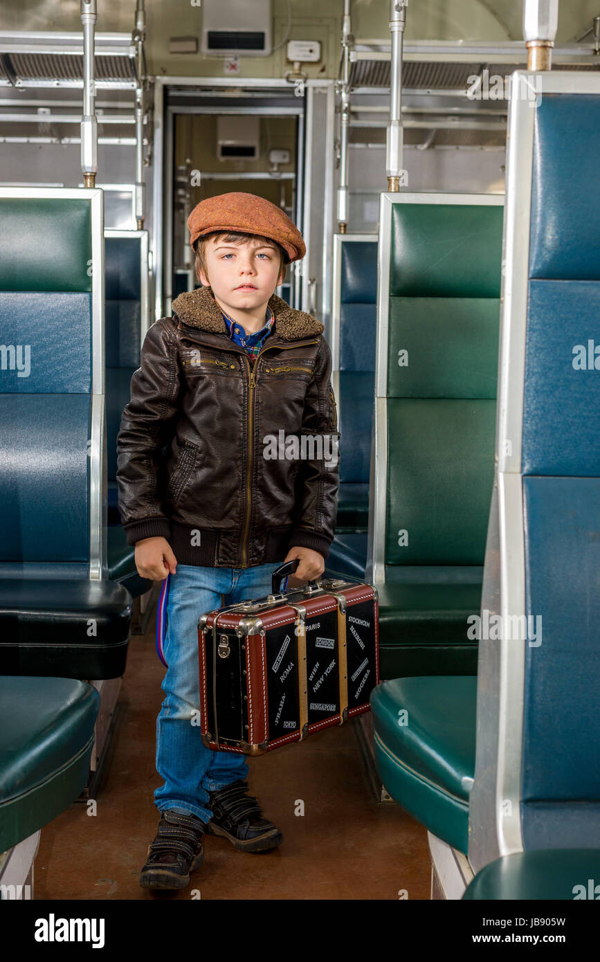 boy traveling in a train with his suitcase Stock Photo - Alamy