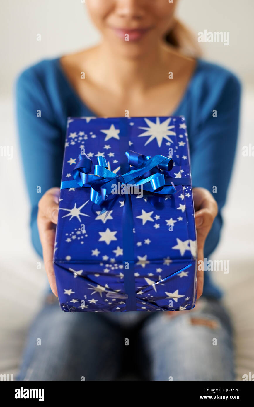 asian woman showing present to the camera and smiling Stock Photo - Alamy