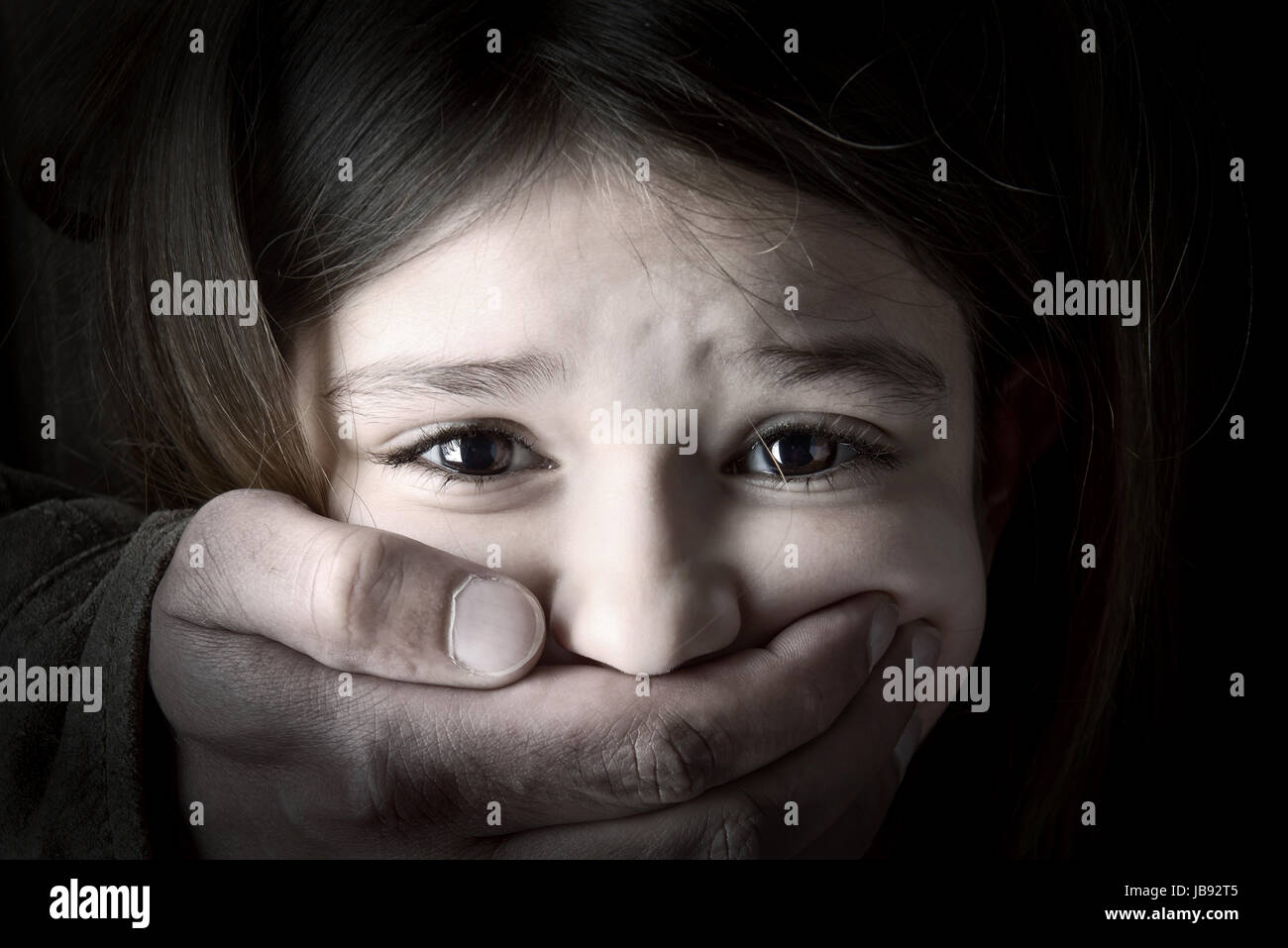 Scared young girl with an adult man's hand covering her mouth Stock ...