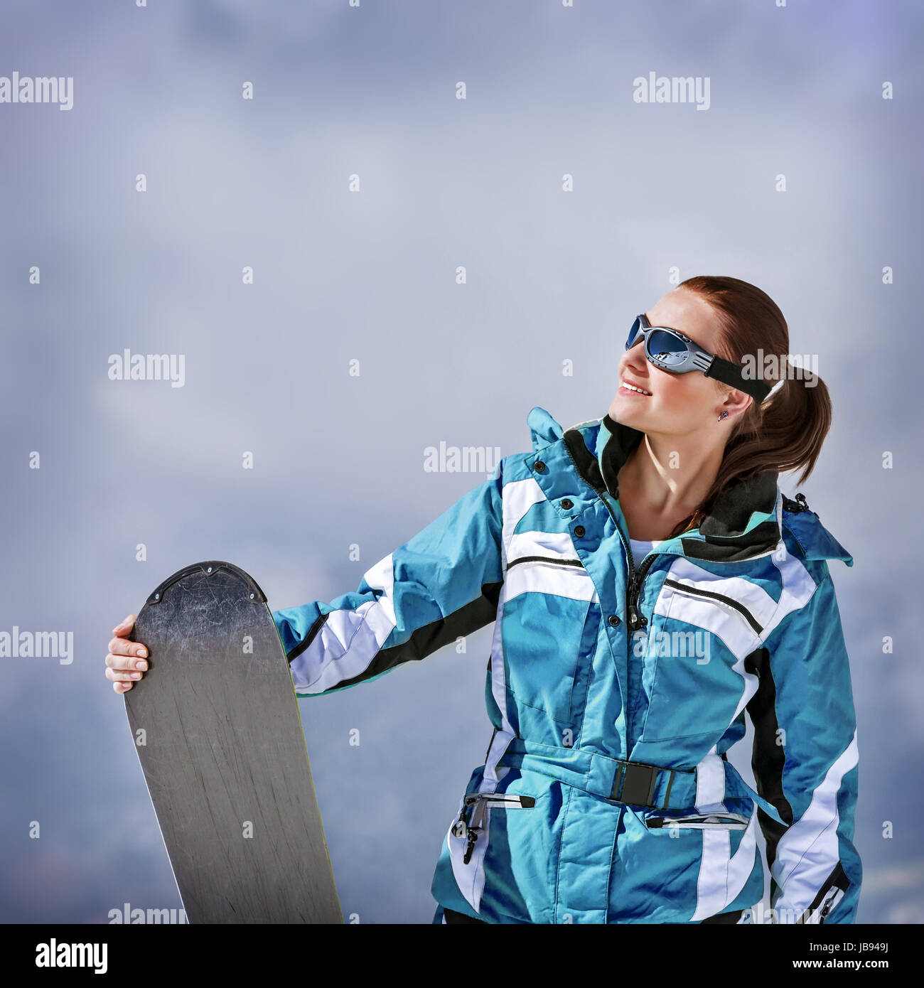 Cute young snowboarder girl having fun outdoors, cloudy sky, ski resort ...