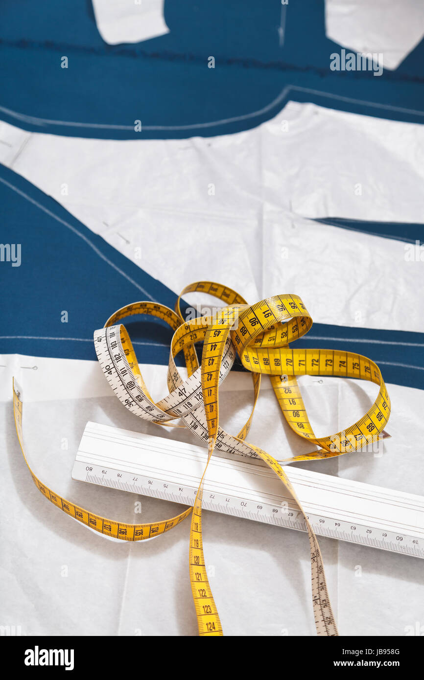 tailor measure tools and paper model of dress on blue fabric for dress ...