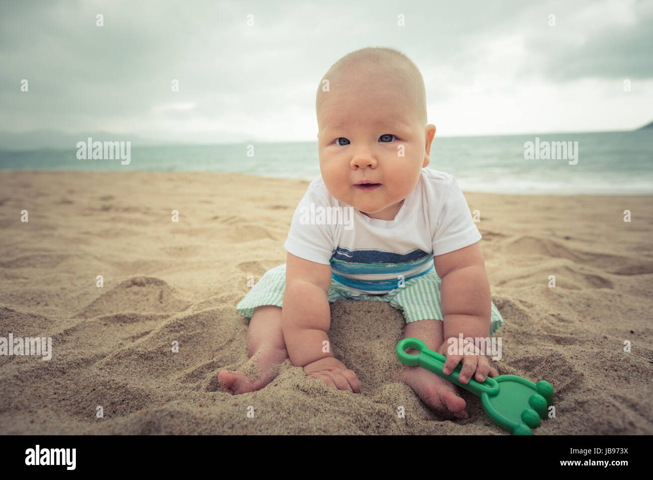 Cute baby sitting on a sand Stock Photo - Alamy