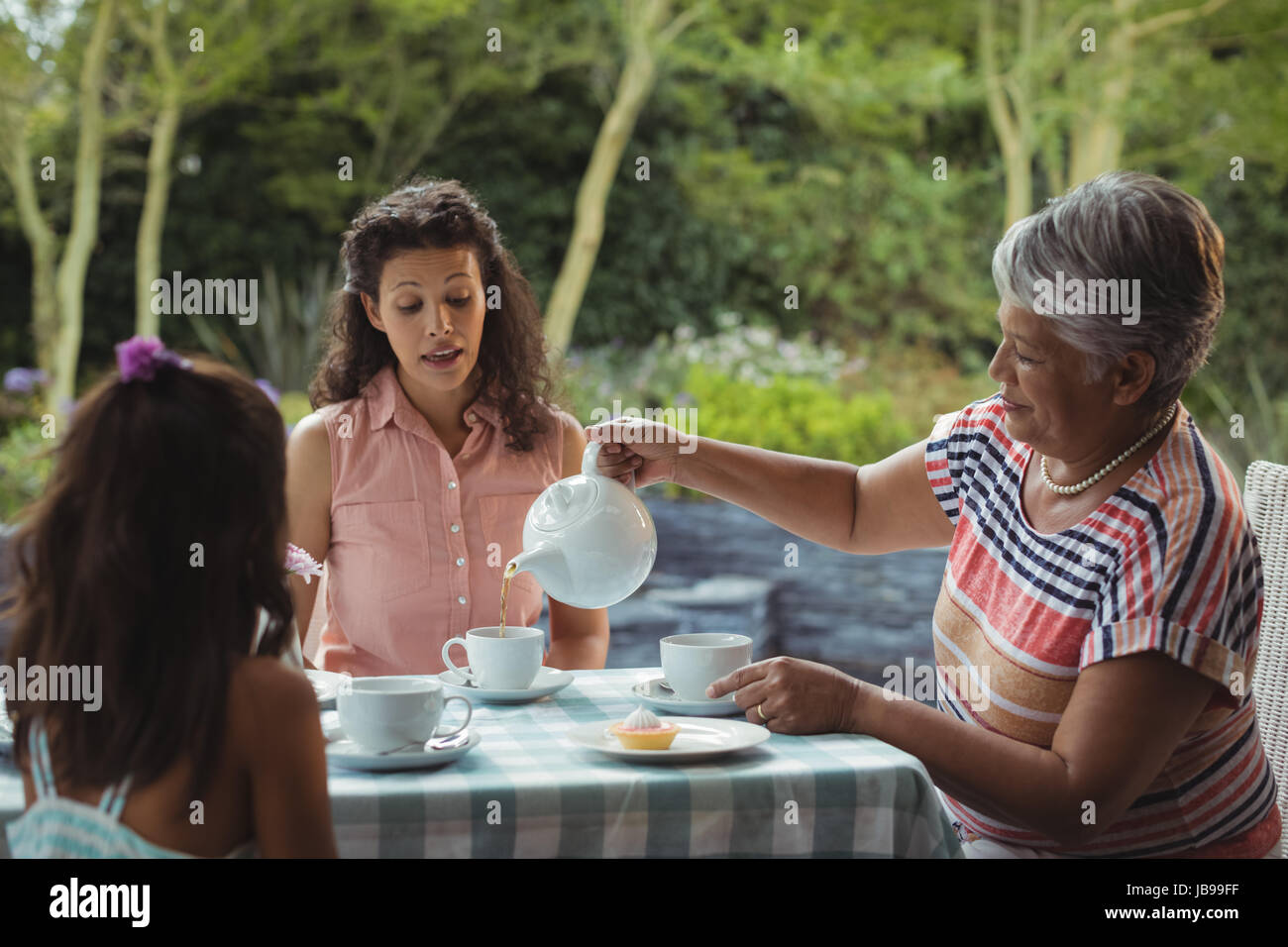 Happy family having tea at home Stock Photo - Alamy