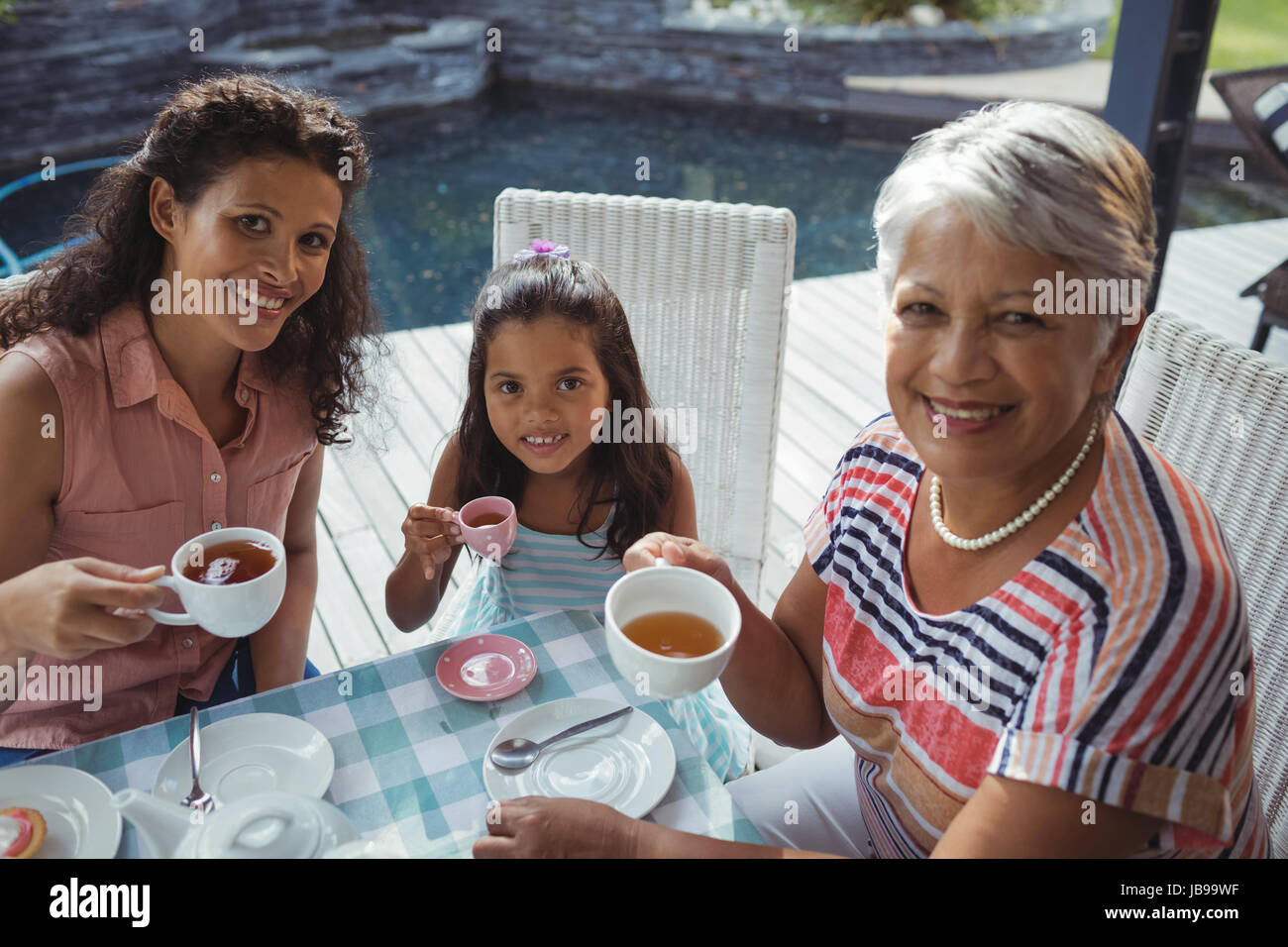 Portrait of happy family having tea at home Stock Photo - Alamy