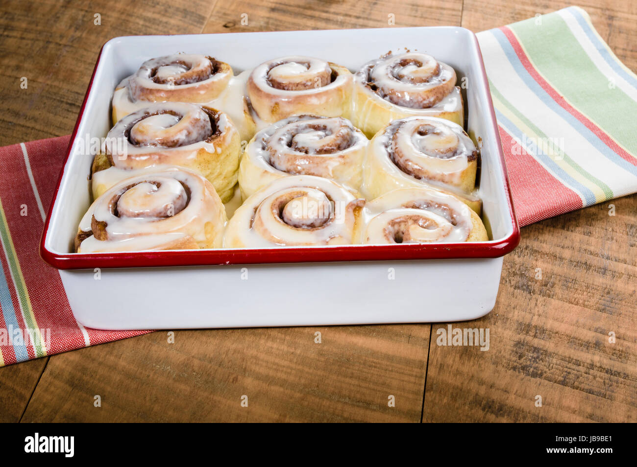 Pan of fresh baked cinnamon rolls with icing Stock Photo - Alamy