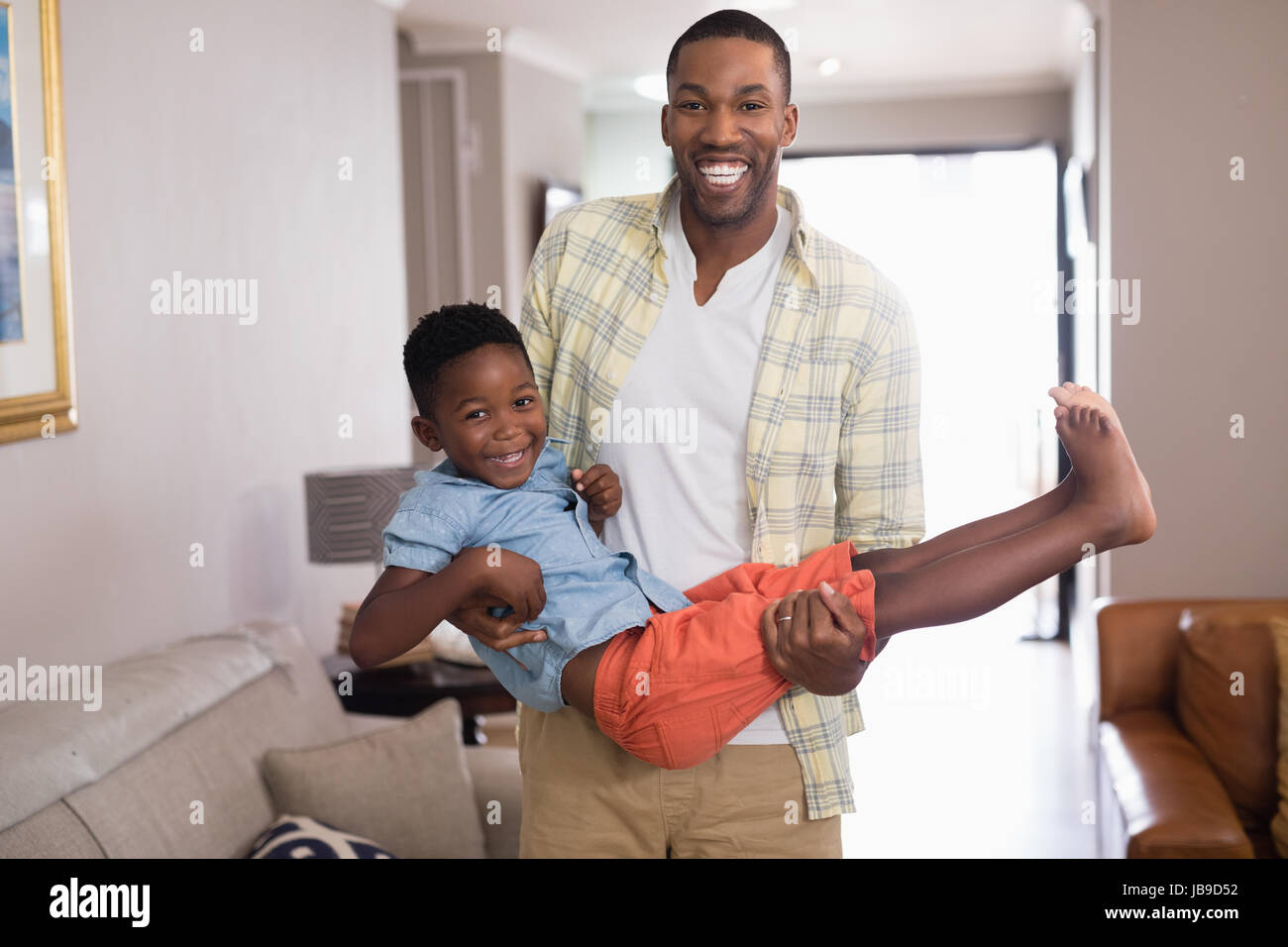 Playful father carrying son in living room at home Stock Photo - Alamy