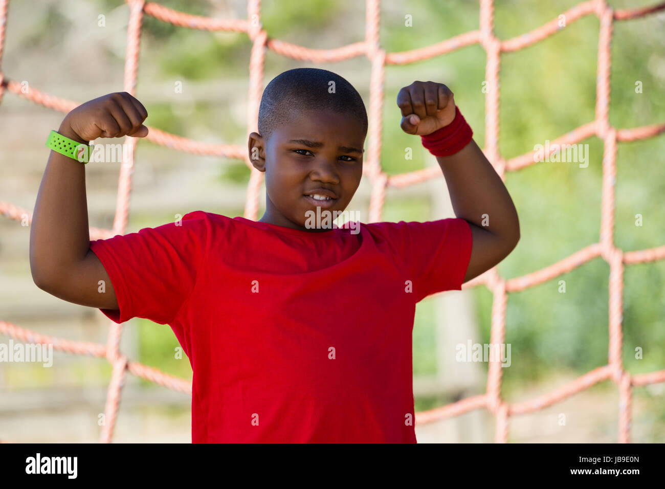 Portrait of boy standing in the boot camp during obstacle course ...
