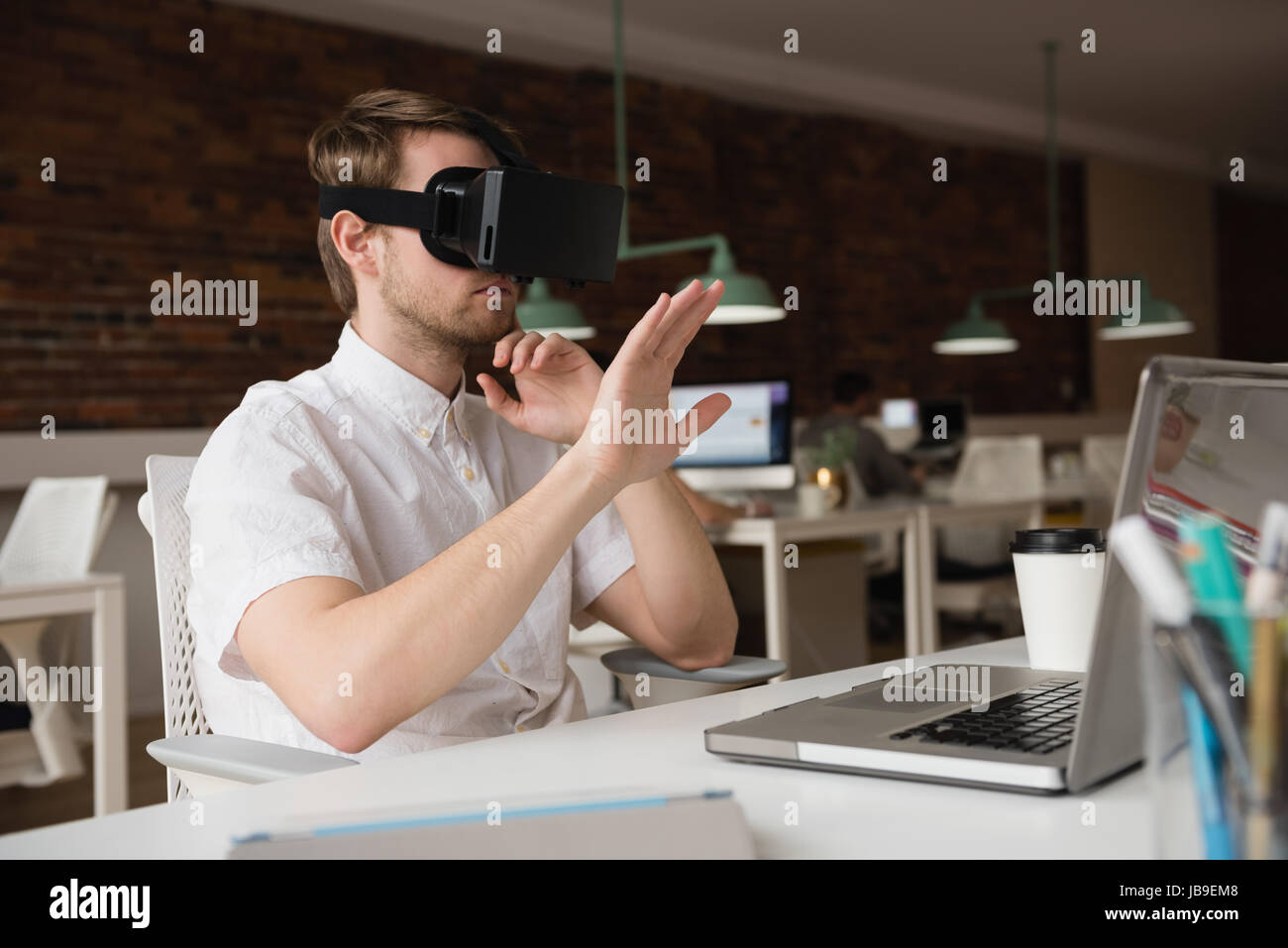 Male executive using virtual reality headset in office Stock Photo - Alamy