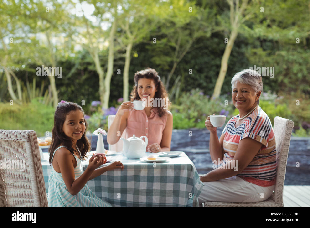Portrait of happy family having tea at home Stock Photo - Alamy