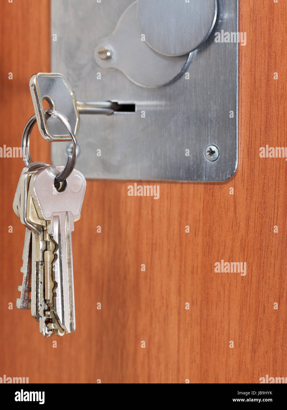 bunch of home keys in keyhole of wooden door Stock Photo - Alamy