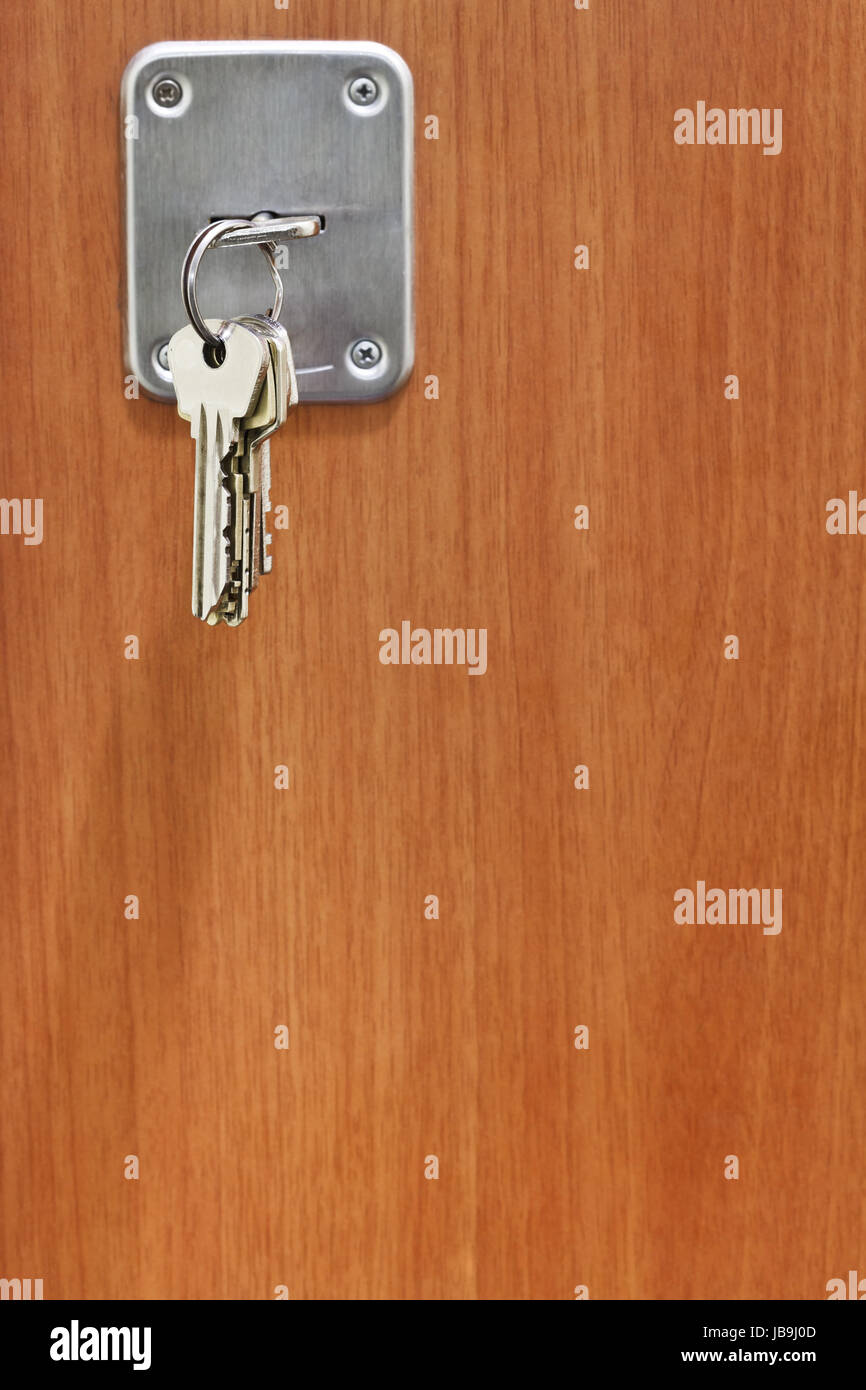 bunch of house keys in keyhole of wooden door Stock Photo - Alamy