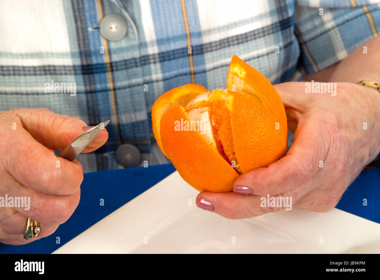 Detail from elderly woman peeling an orange - isolated on white ...