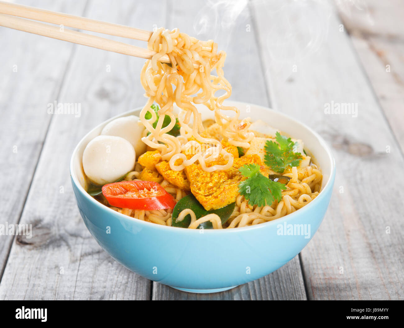 Spicy curry instant noodles with chopsticks. Asian cuisine, ready to ...