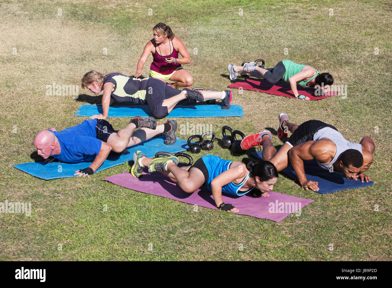 Young fitness instructor working with mixed group of adults Stock Photo ...