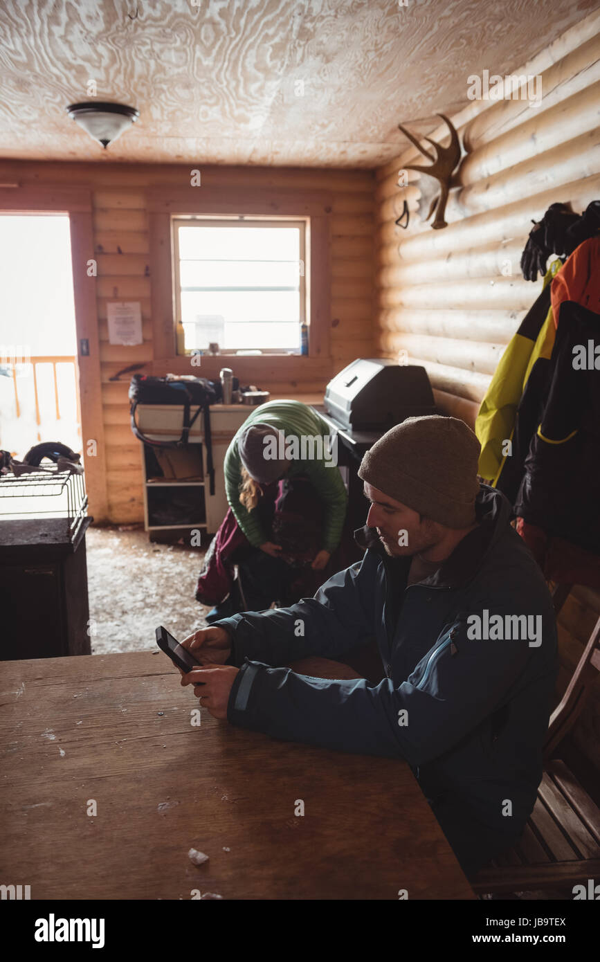 Man using mobile phone in the log cabin Stock Photo - Alamy