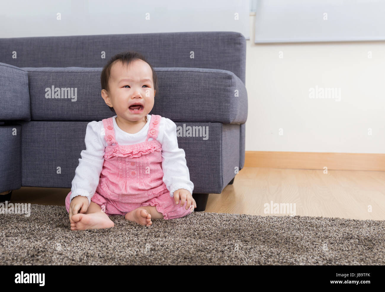 Baby girl crying at home Stock Photo - Alamy