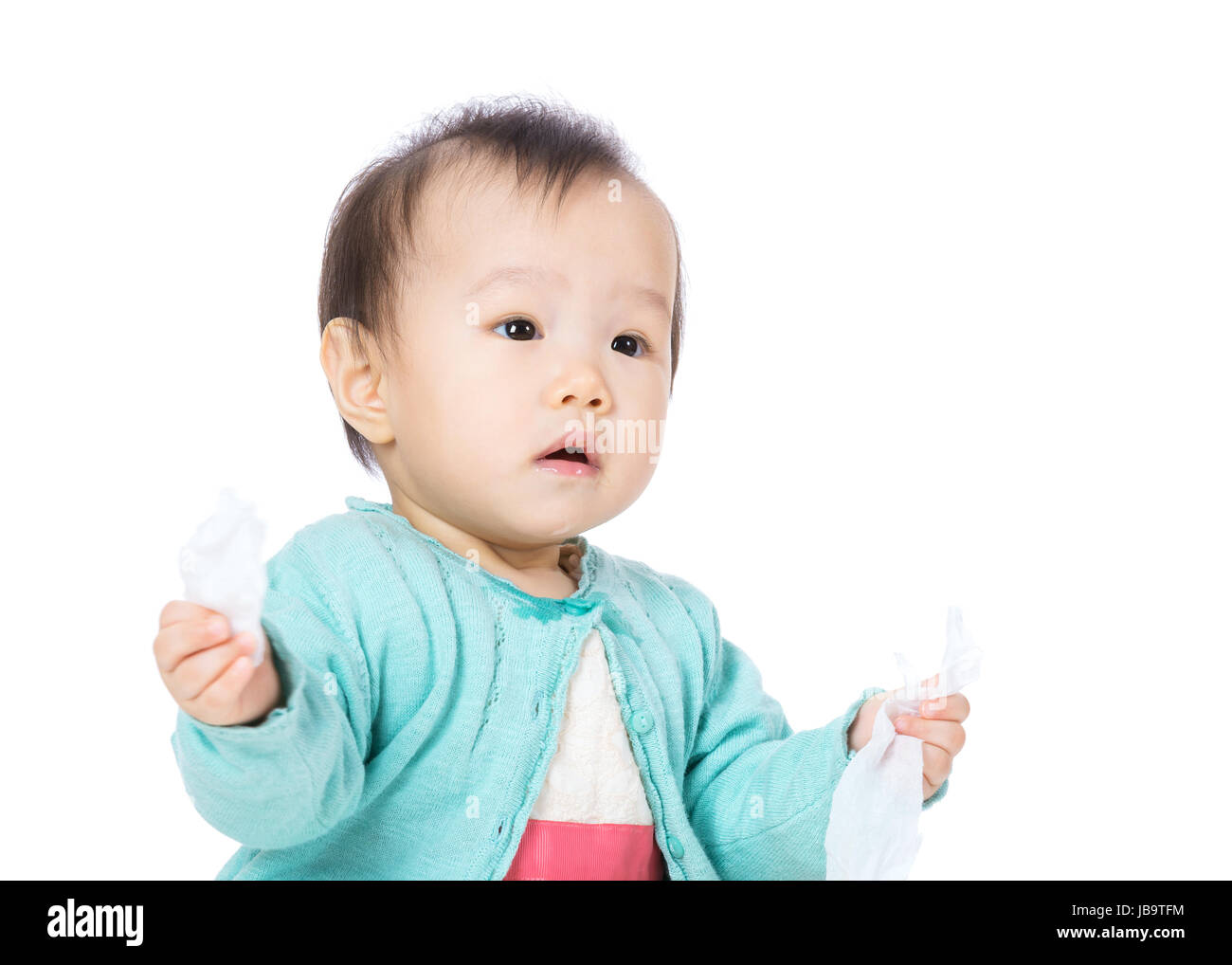 Baby girl with tissue on hand Stock Photo - Alamy
