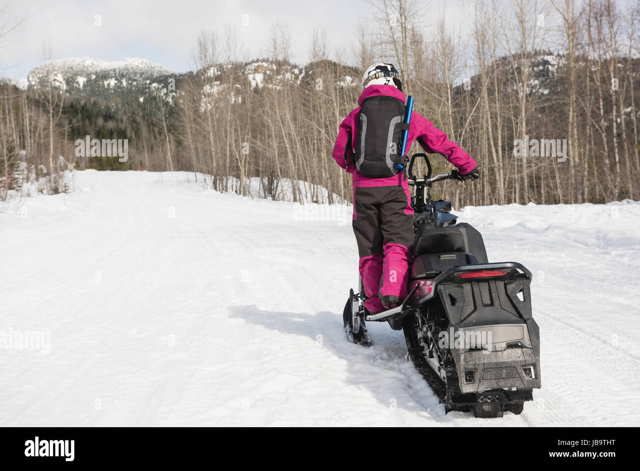 Woman riding snowmobile in snowy alps during winter Stock Photo - Alamy