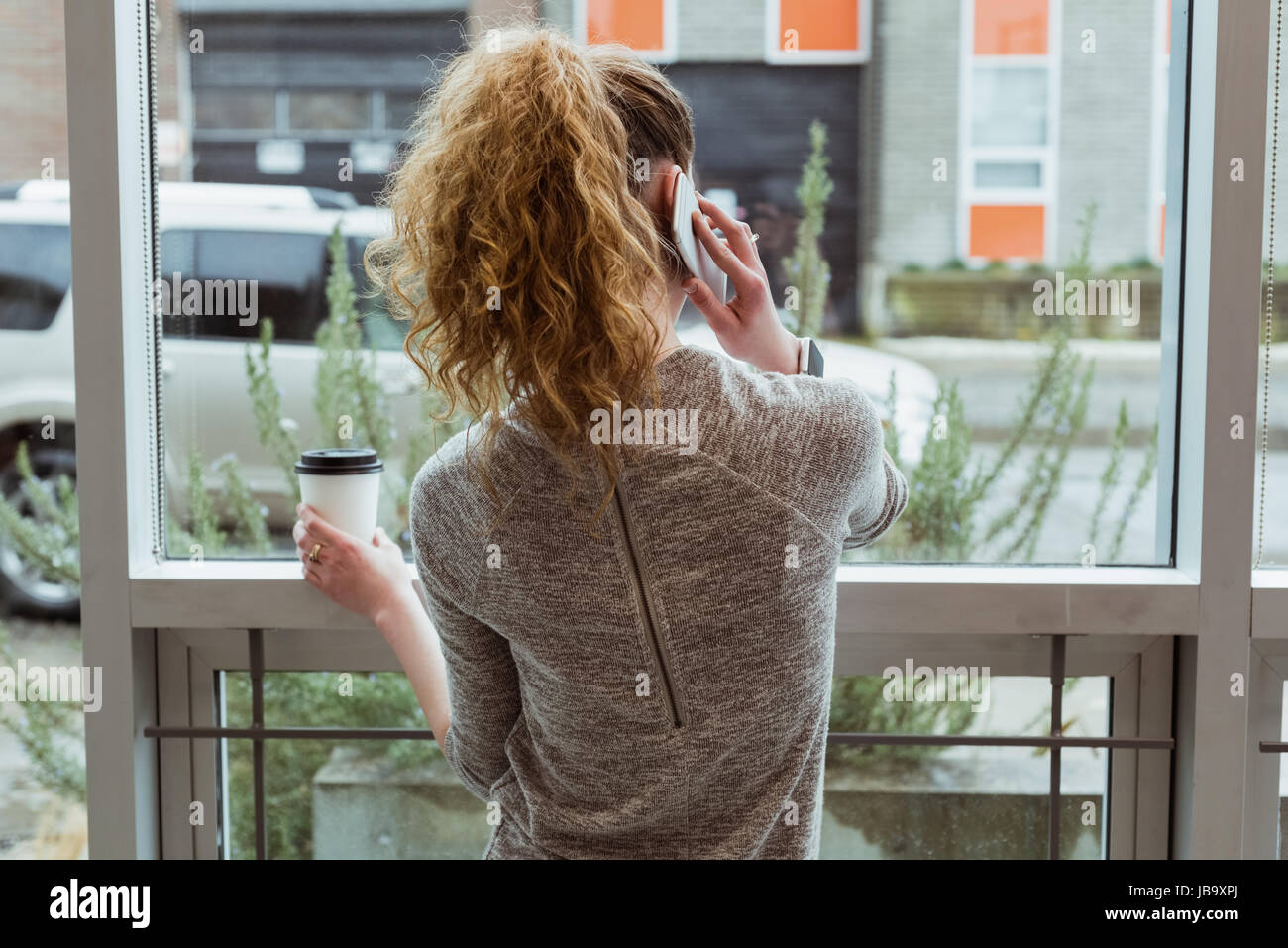 Rear view of female executive talking on mobile phone in office Stock ...