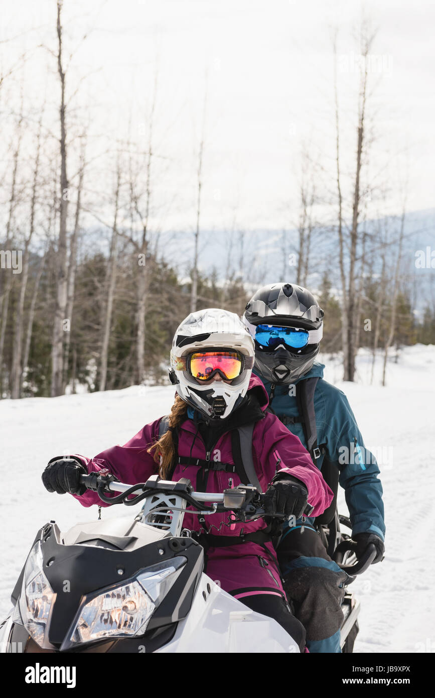 Couple riding snowmobile in snowy alps during winter Stock Photo - Alamy
