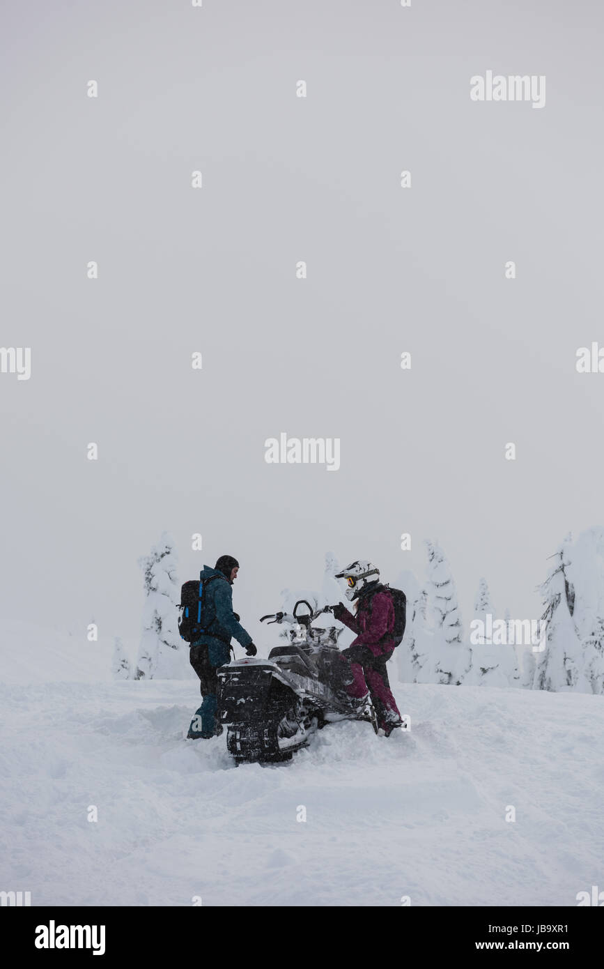 Couple ready to ride snowmobile in snowy alps during winter Stock Photo ...