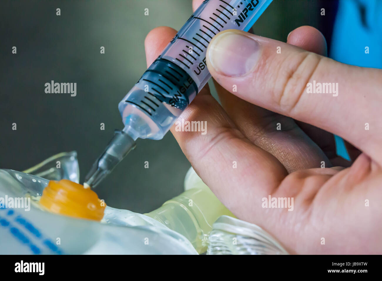 Nurse withdraws fluids with needle and syringe Stock Photo - Alamy