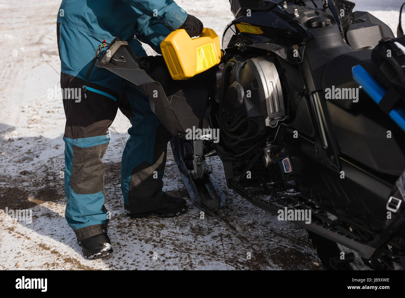 Man filling gas tank of snowmobile during winter Stock Photo - Alamy