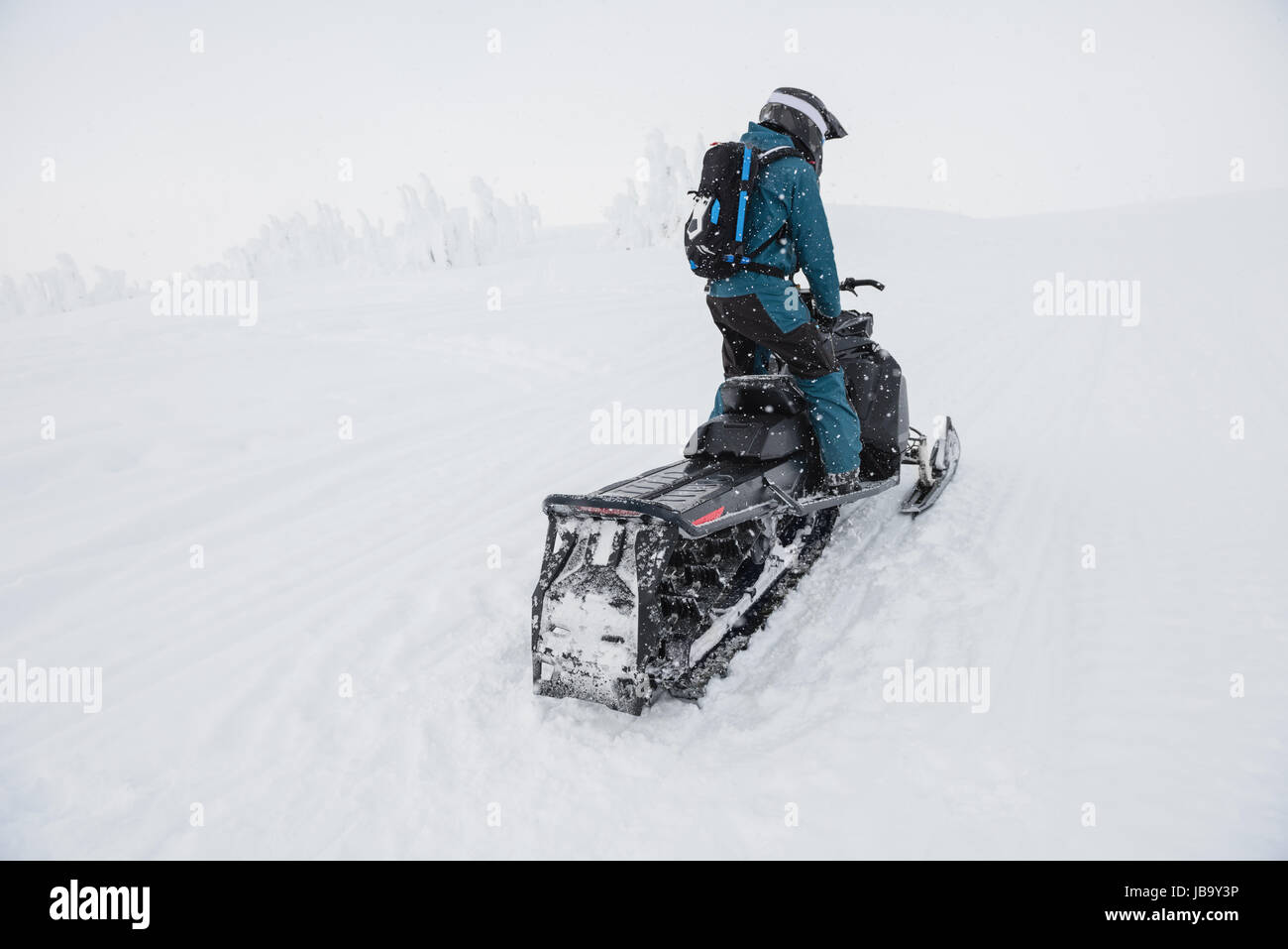 Man riding snowmobile in snowy alps during winter Stock Photo - Alamy
