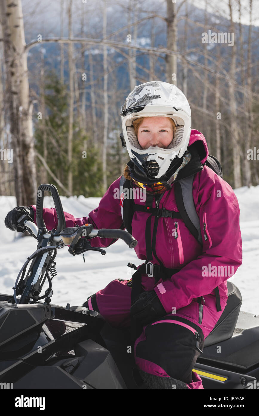 Woman relaxing on snowmobile during winter Stock Photo - Alamy