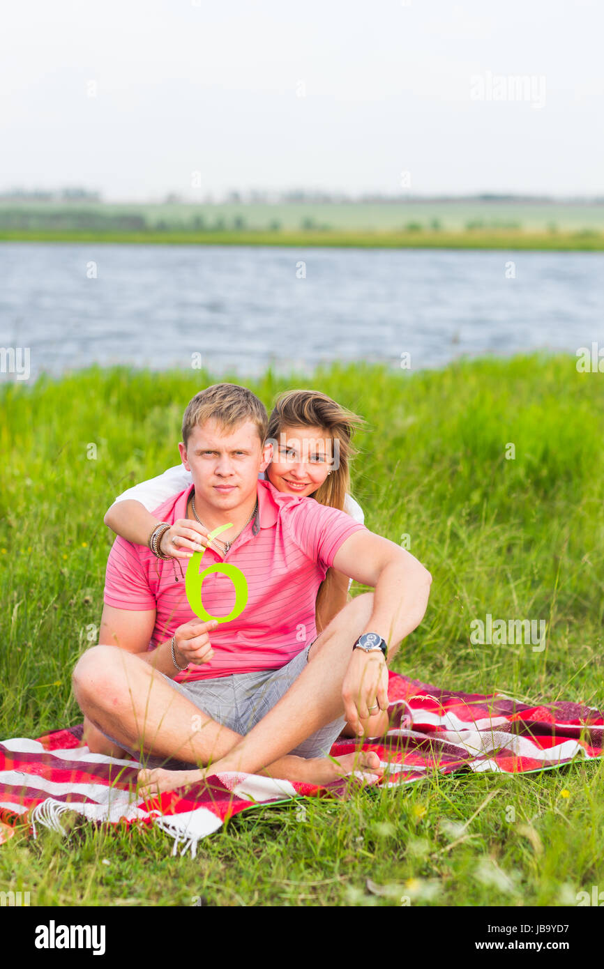 Man and woman holding the number 6 in nature. Concept of numbers ...