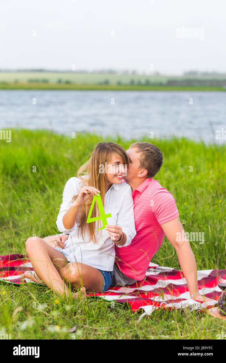 Man and woman holding the number 4 in nature. Concept of numbers ...