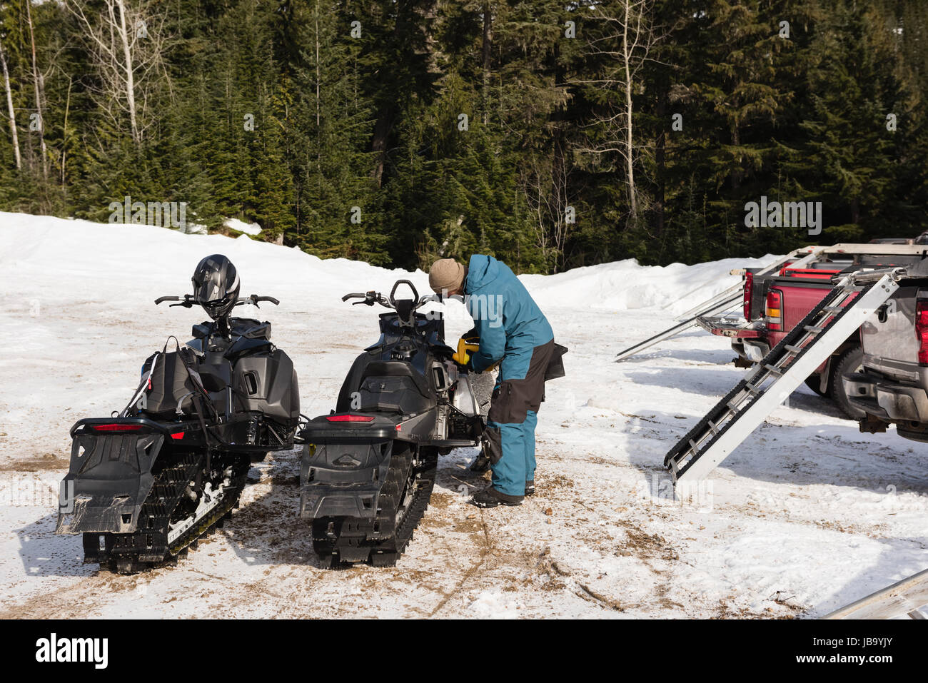 Man filling gas tank of snowmobile during winter Stock Photo - Alamy