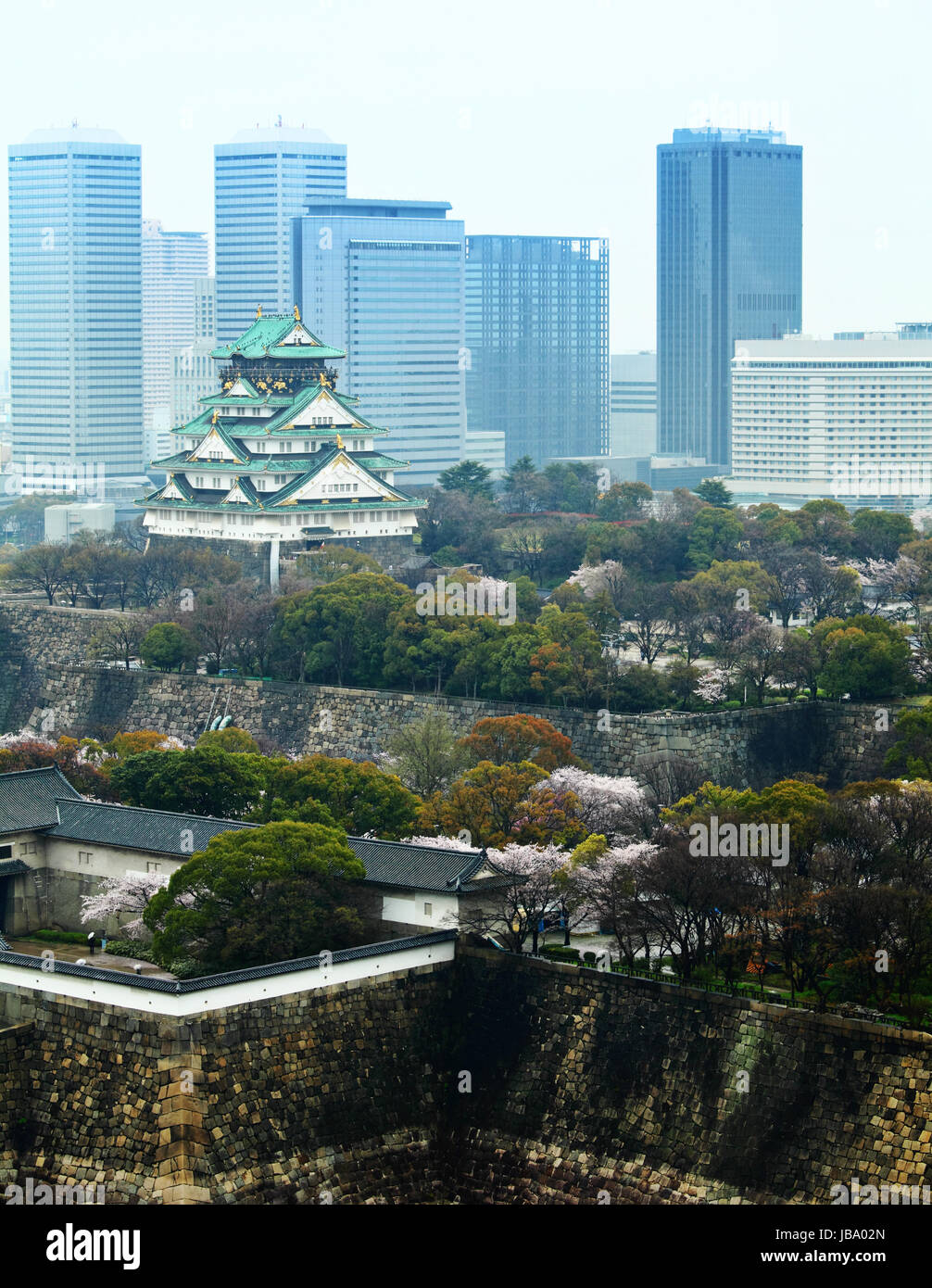 Osaka castle with modern building background Stock Photo - Alamy