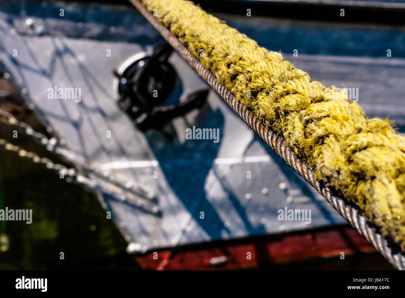 Thick yellow hawser, mooring line with blurred visible fragment of the ...