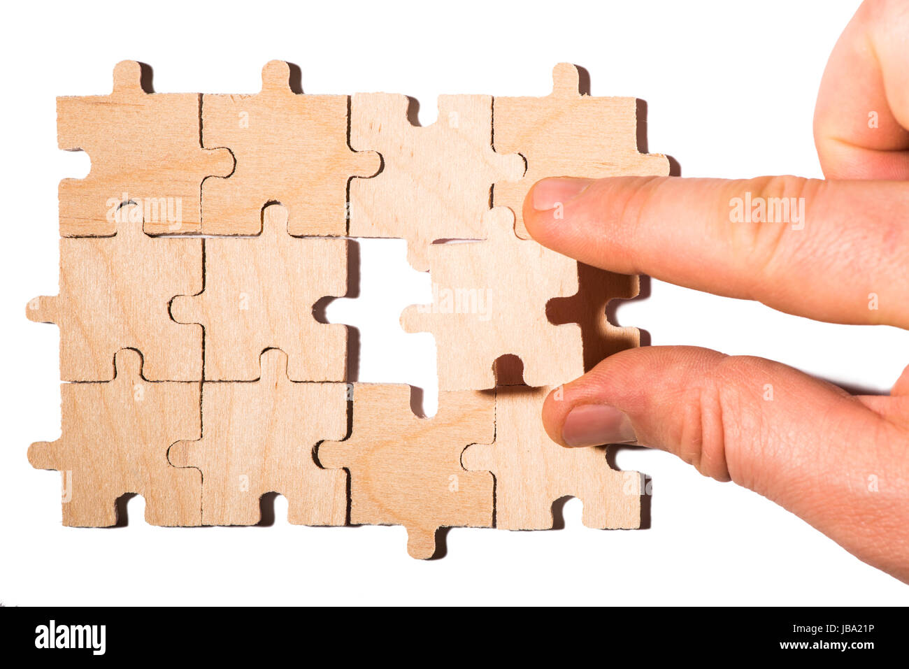 Wooden puzzle on white background. . Hand holding puzzle piece. White ...