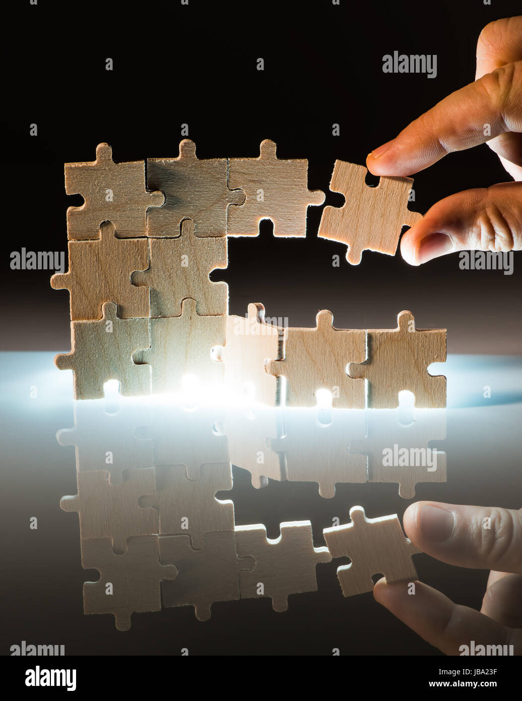 Wooden puzzle and backlight background. Vertically stacked parts. Hand ...