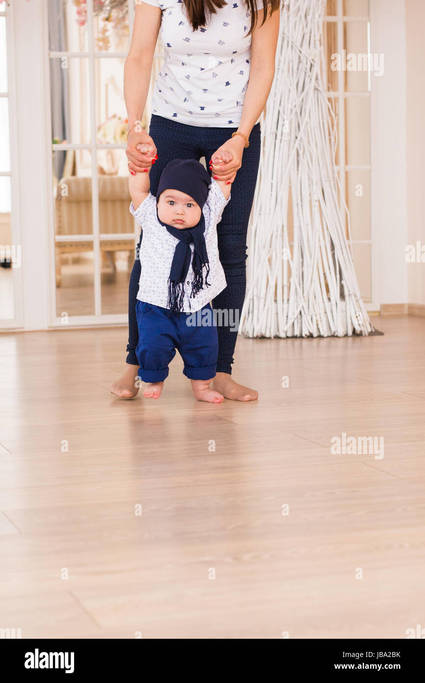 baby taking first steps with mother help Stock Photo - Alamy